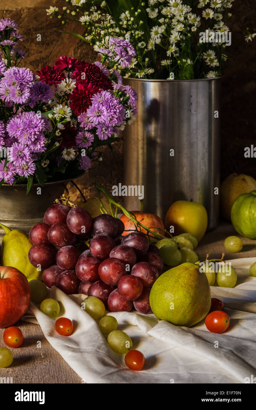 Still life with Fruits were placed together with a vase of flowers ...