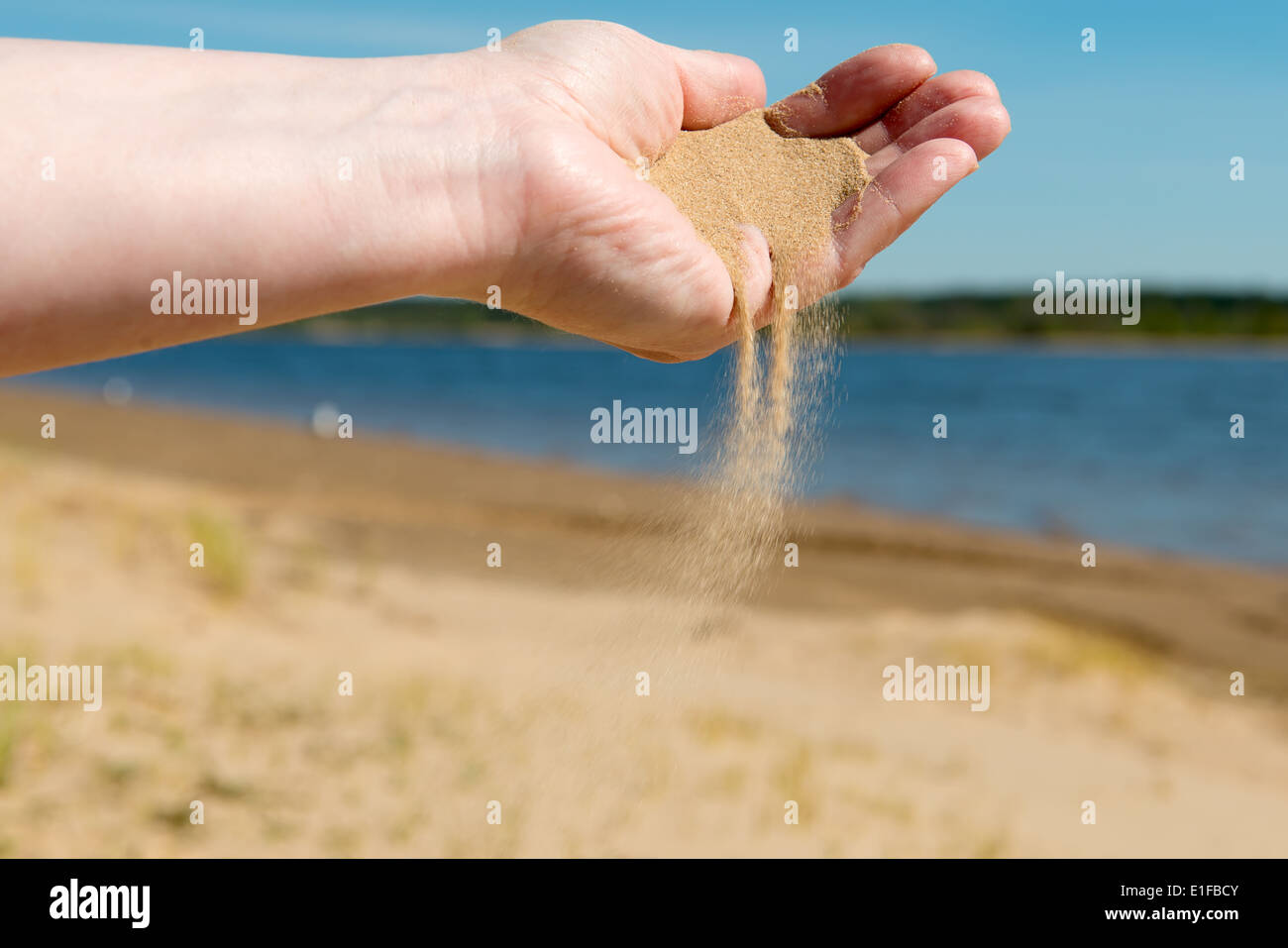 Sand from female hands crumbles in the wind Stock Photo - Alamy
