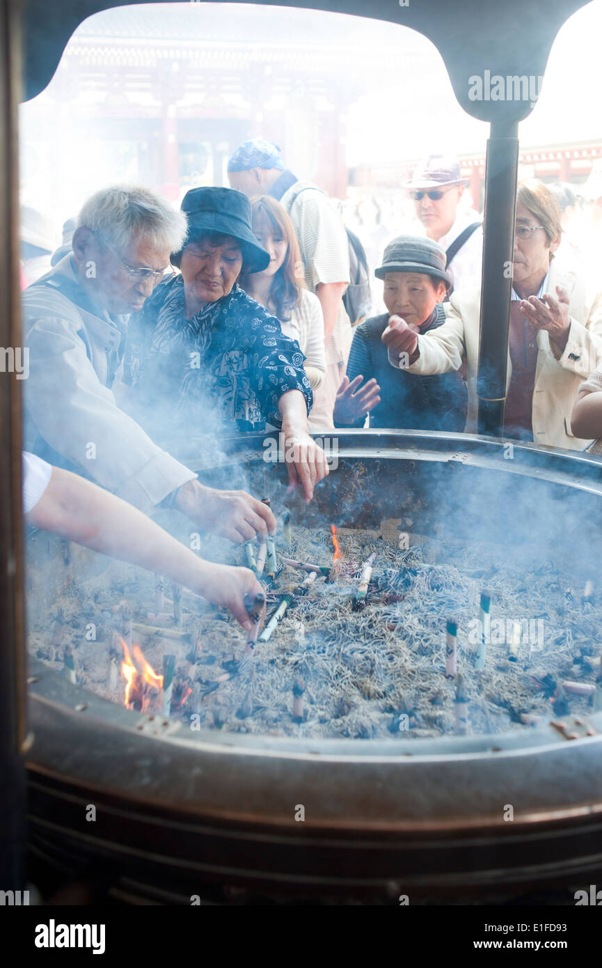 Tokyo, Japan - 2014 - Japaneese people wafting smoke from incense ...
