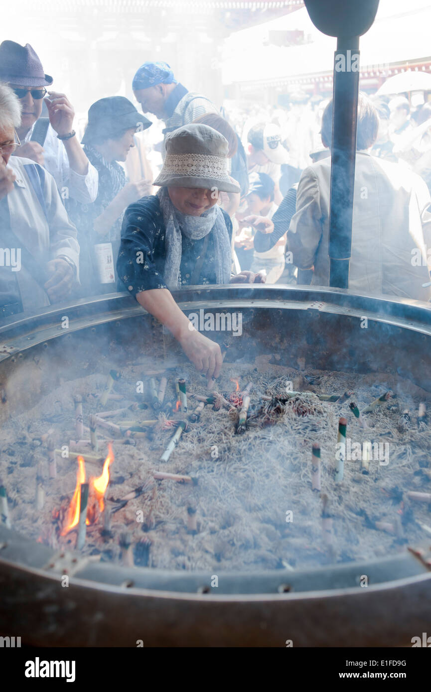 Tokyo, Japan - 2014 - Japaneese people wafting smoke from incense ...