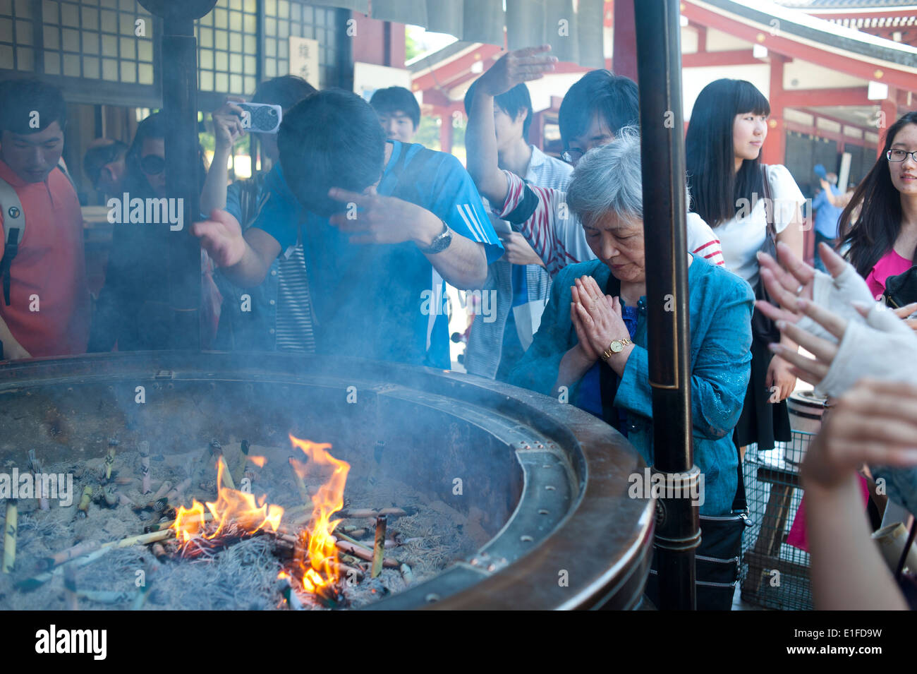 Tokyo, Japan - 2014 - Japaneese people wafting smoke from incense ...