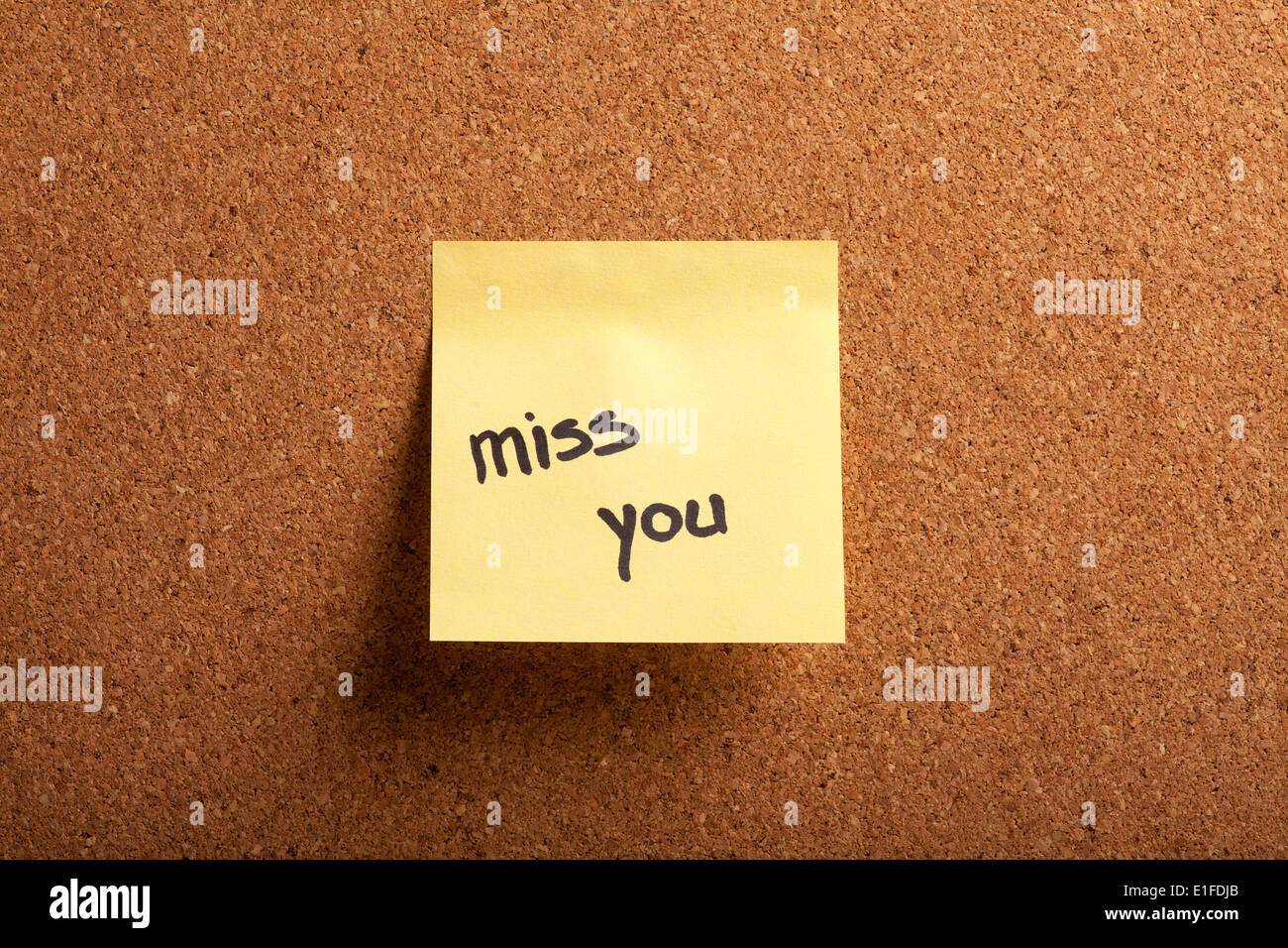 Color shot of a cork board with a sticky note reading "miss you Stock ...
