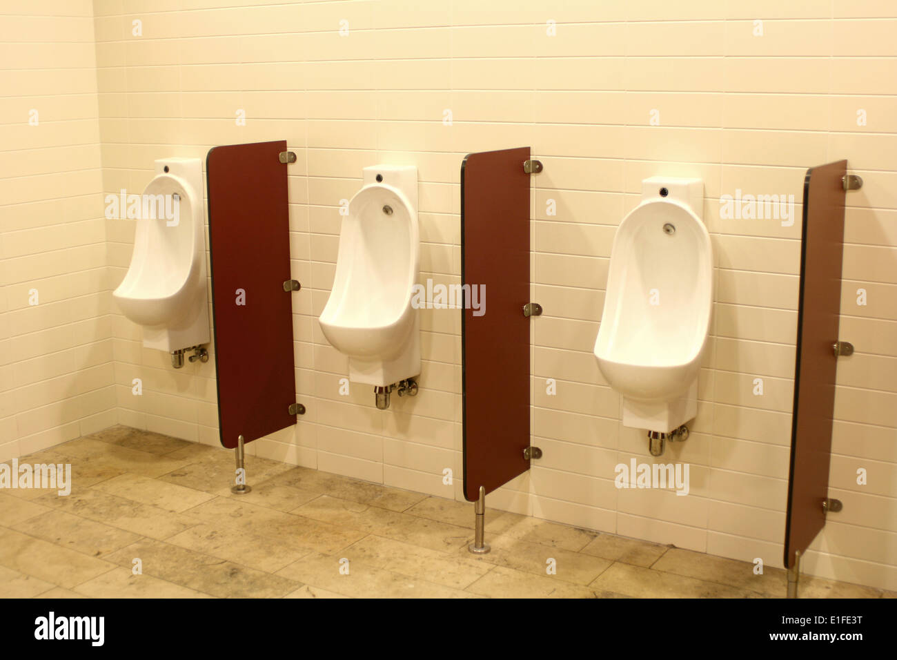 Three men urinals in the public restroom Stock Photo - Alamy