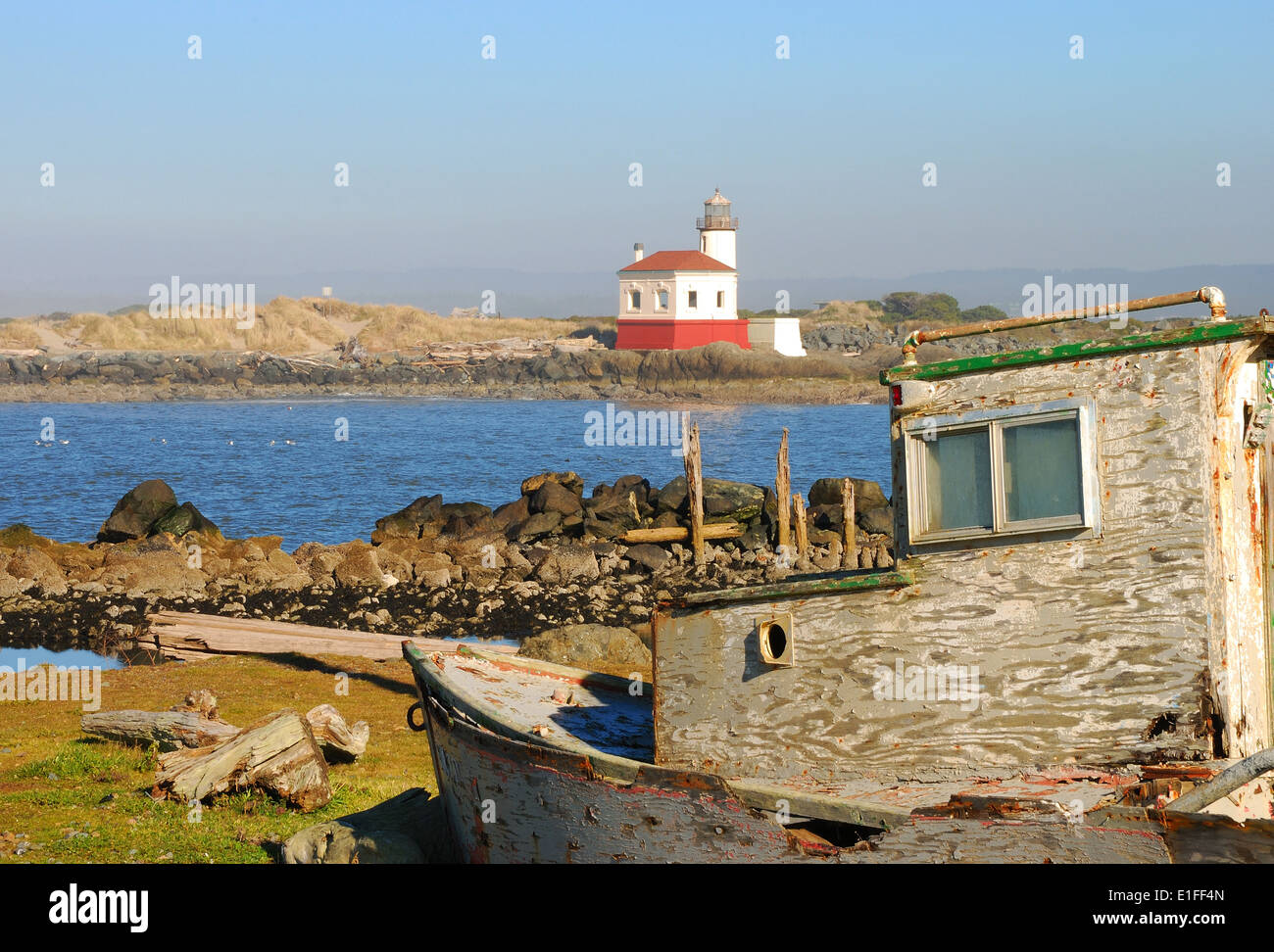 Old shored boat and the Coquille River Lighthouse, also called Bandon ...