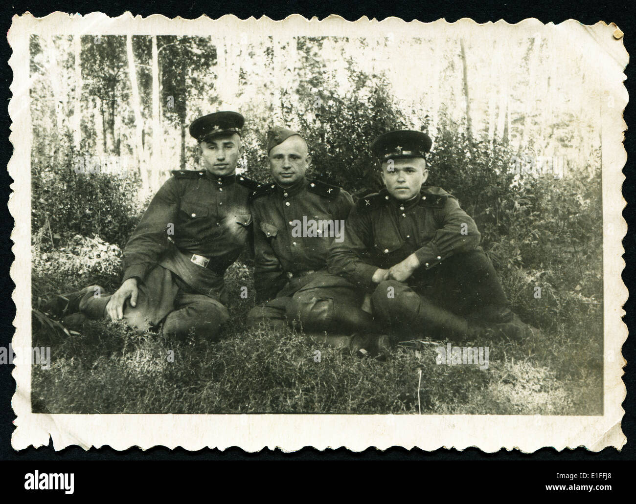USSR - CIRCA 1953: Postcard shows three soldiers sitting under a tree ...