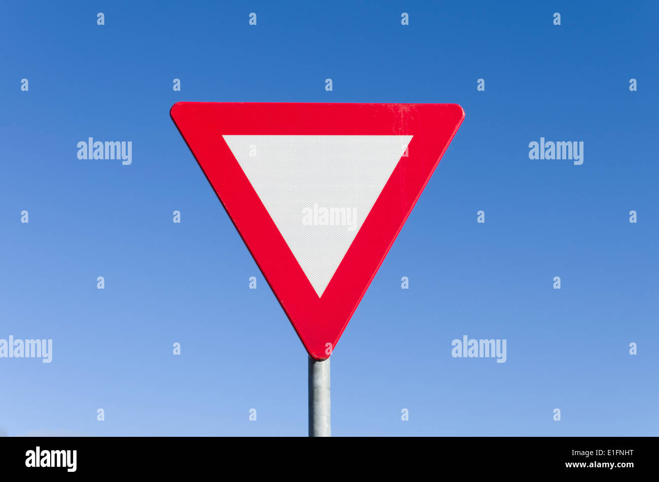 give way traffic sign against a clear blue sky Stock Photo - Alamy
