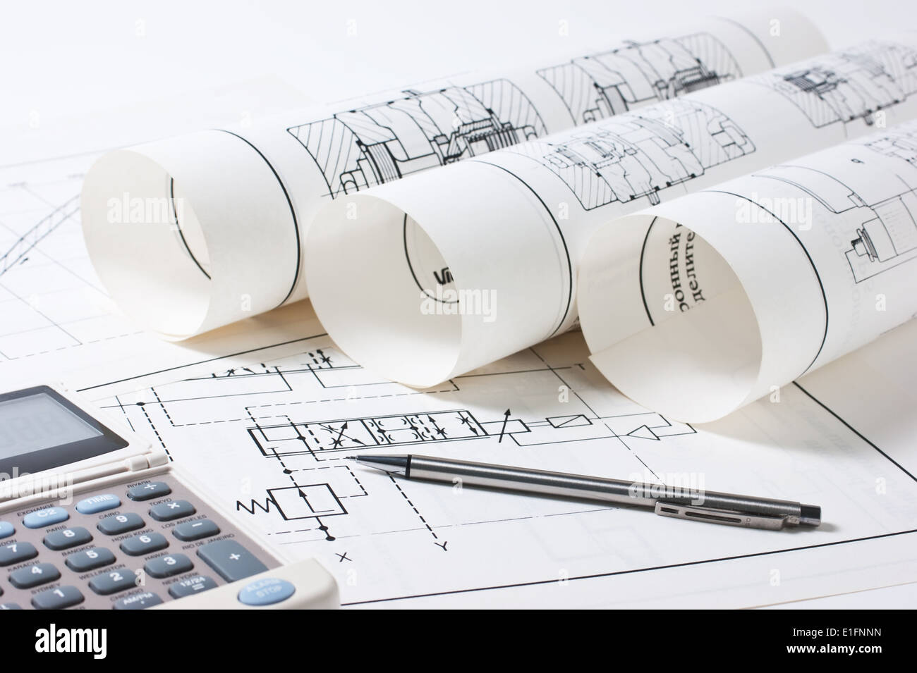 rolled technical drawings and a calculator Stock Photo - Alamy