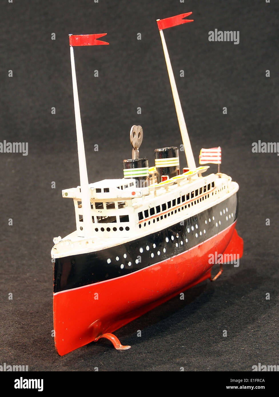 This old tin toy ship, powered by a clockwork mechanism, represents a ...