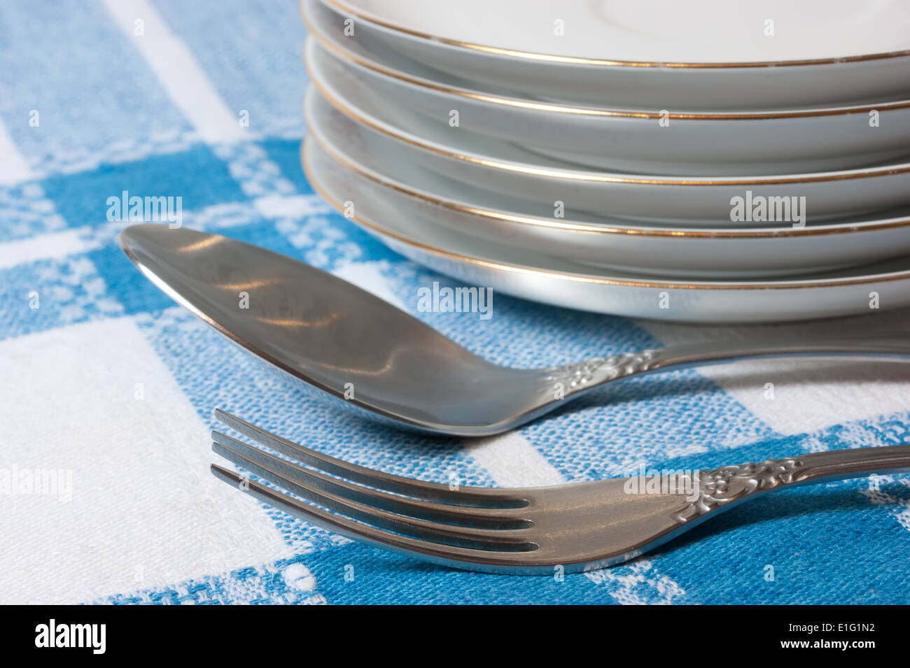 fork and spoon stack of plates on the table Stock Photo - Alamy