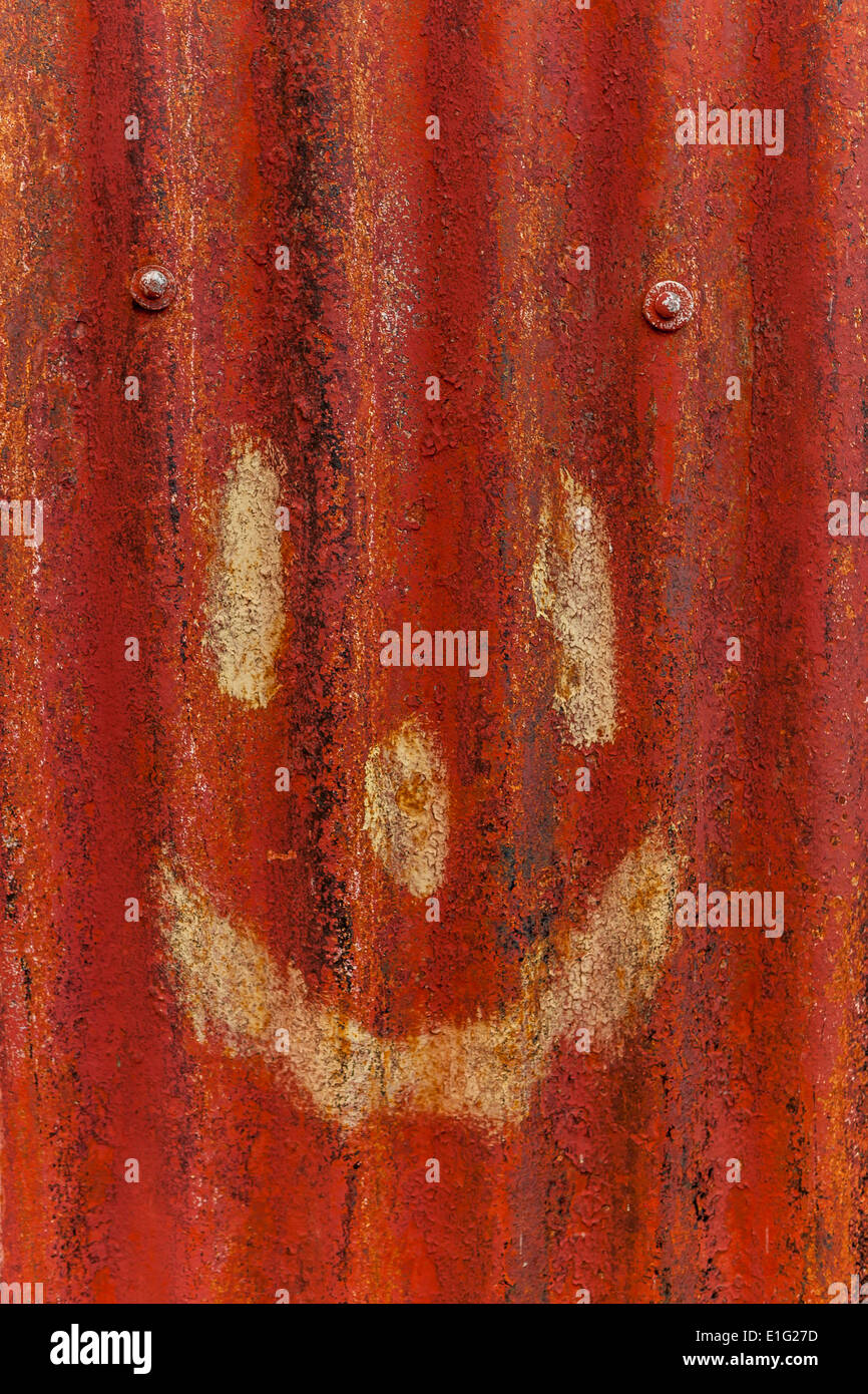 A smiley face painted on some corrugated iron sheeting Stock Photo - Alamy