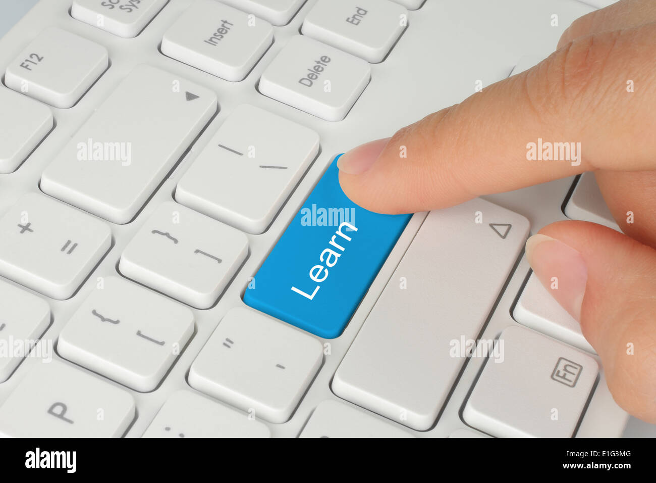 Hand pushing blue learn keyboard button Stock Photo - Alamy