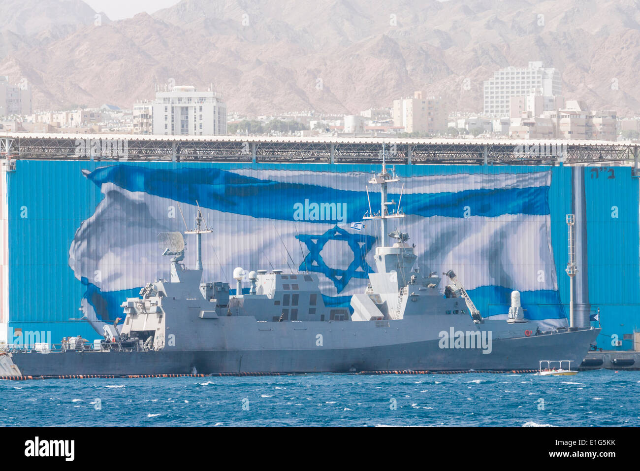 Eilat. A "Saar 5" missile frigate anchored along a large Israeli flag ...
