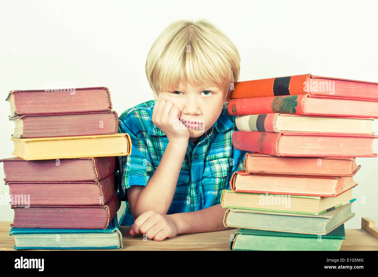 Fed up little boy with learning books Stock Photo - Alamy