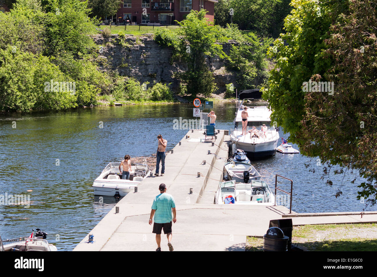 People relaxing on the dock with moored boats and cabin cruiser on a ...
