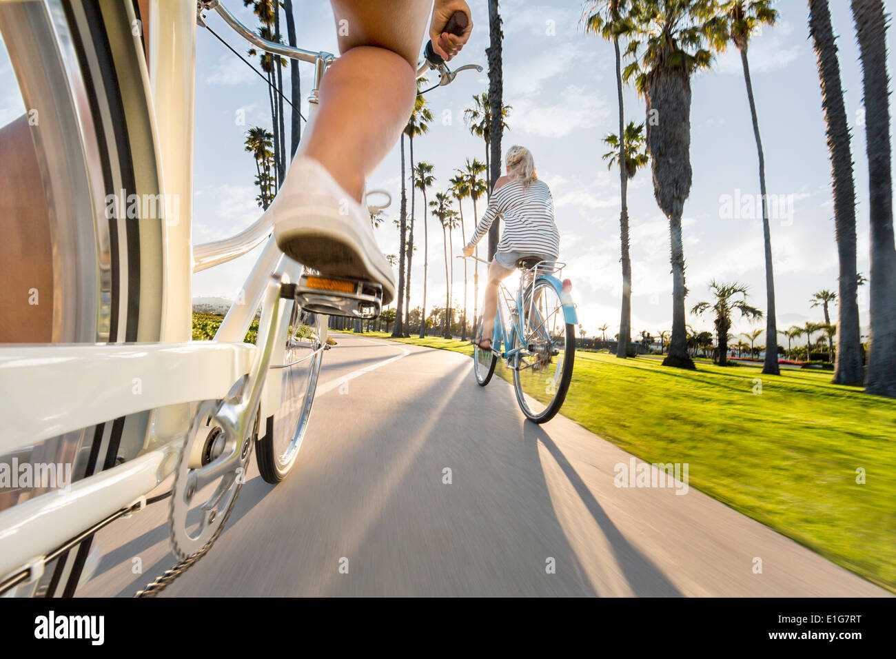 A unique angle of two women riding their bikes down the bike path on ...