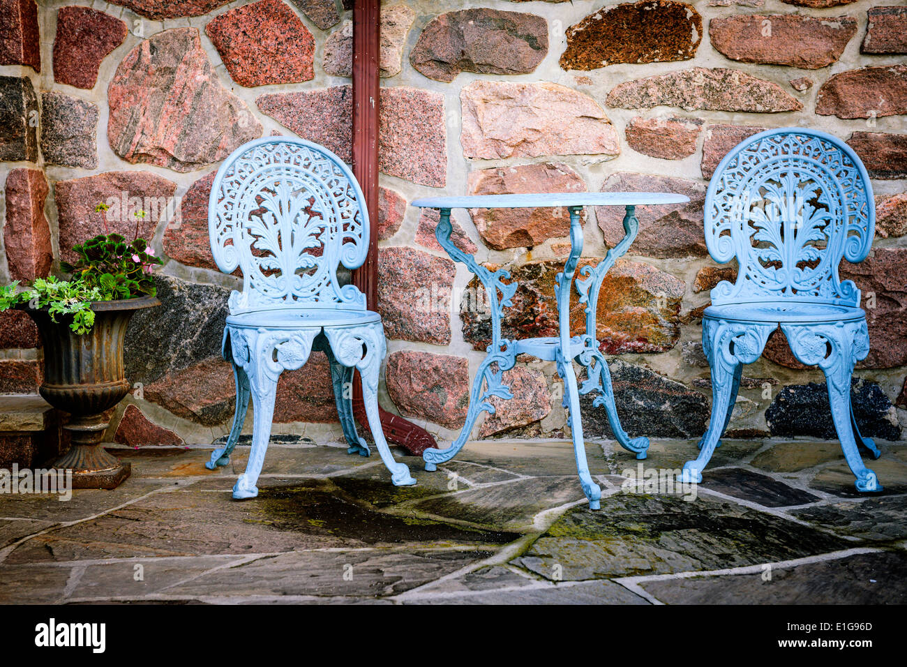 Blue painted metal outdoor furniture on stone patio Stock Photo - Alamy