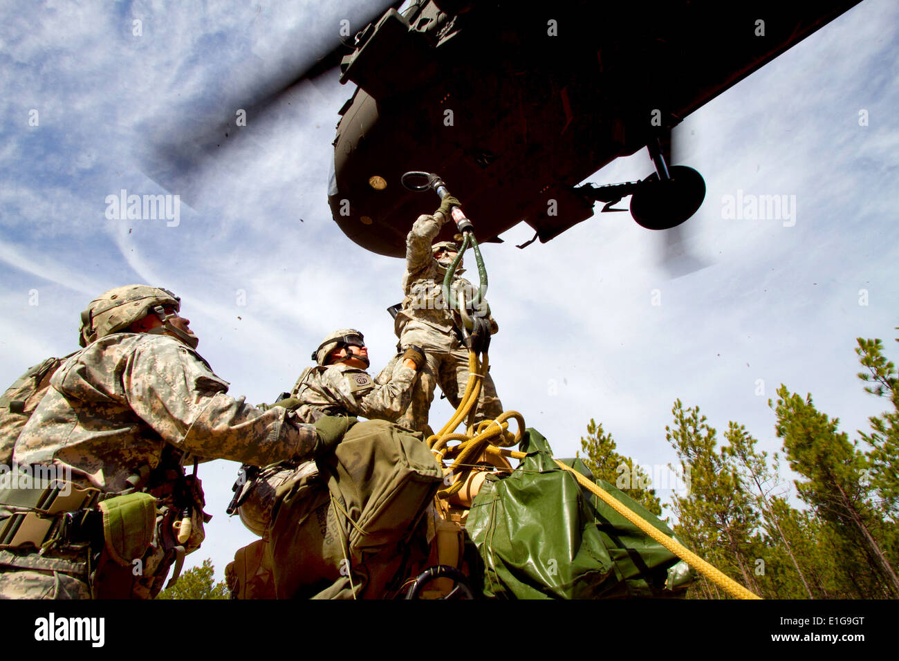 U.S. Army paratroopers sling load an M-119A2 105 mm howitzer to a UH ...