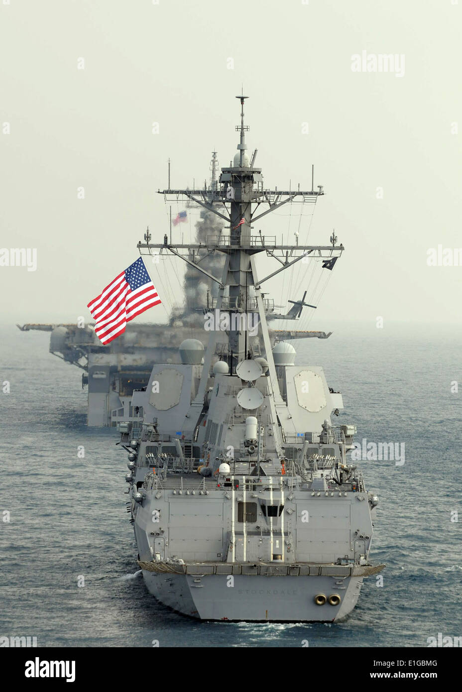 The guided missile destroyer USS Stockdale (DDG 106) maneuvers behind ...