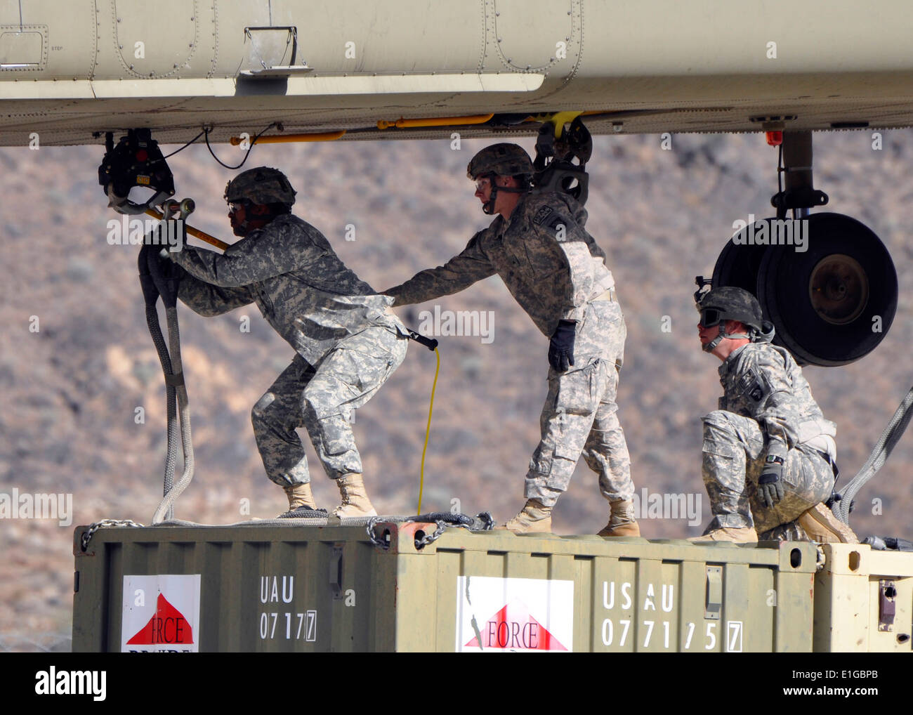 U.S. Army Sgt. Marice Campbell, left, connects containers to a CH-47 ...