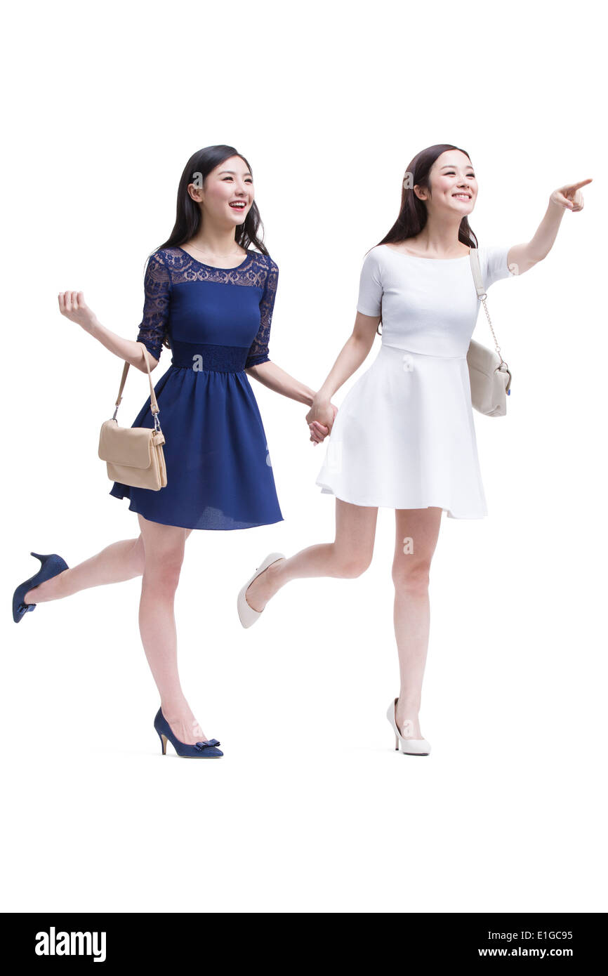 Female friends running hand in hand Stock Photo - Alamy