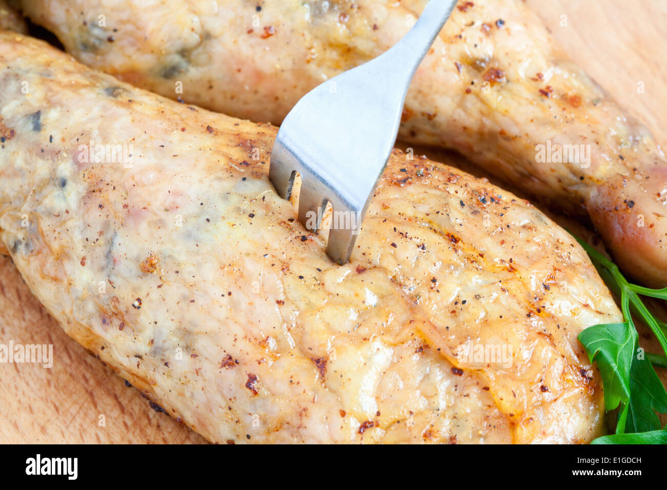 Pierce the chicken with a fork on a cutting board Stock Photo - Alamy