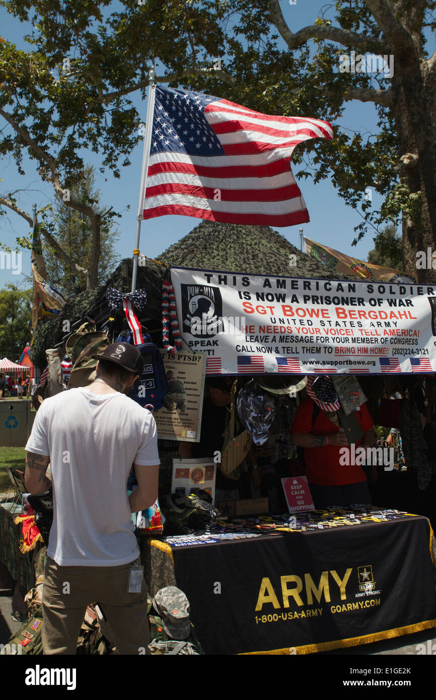 A patriotic military stall at a street fair with a sign asking for ...
