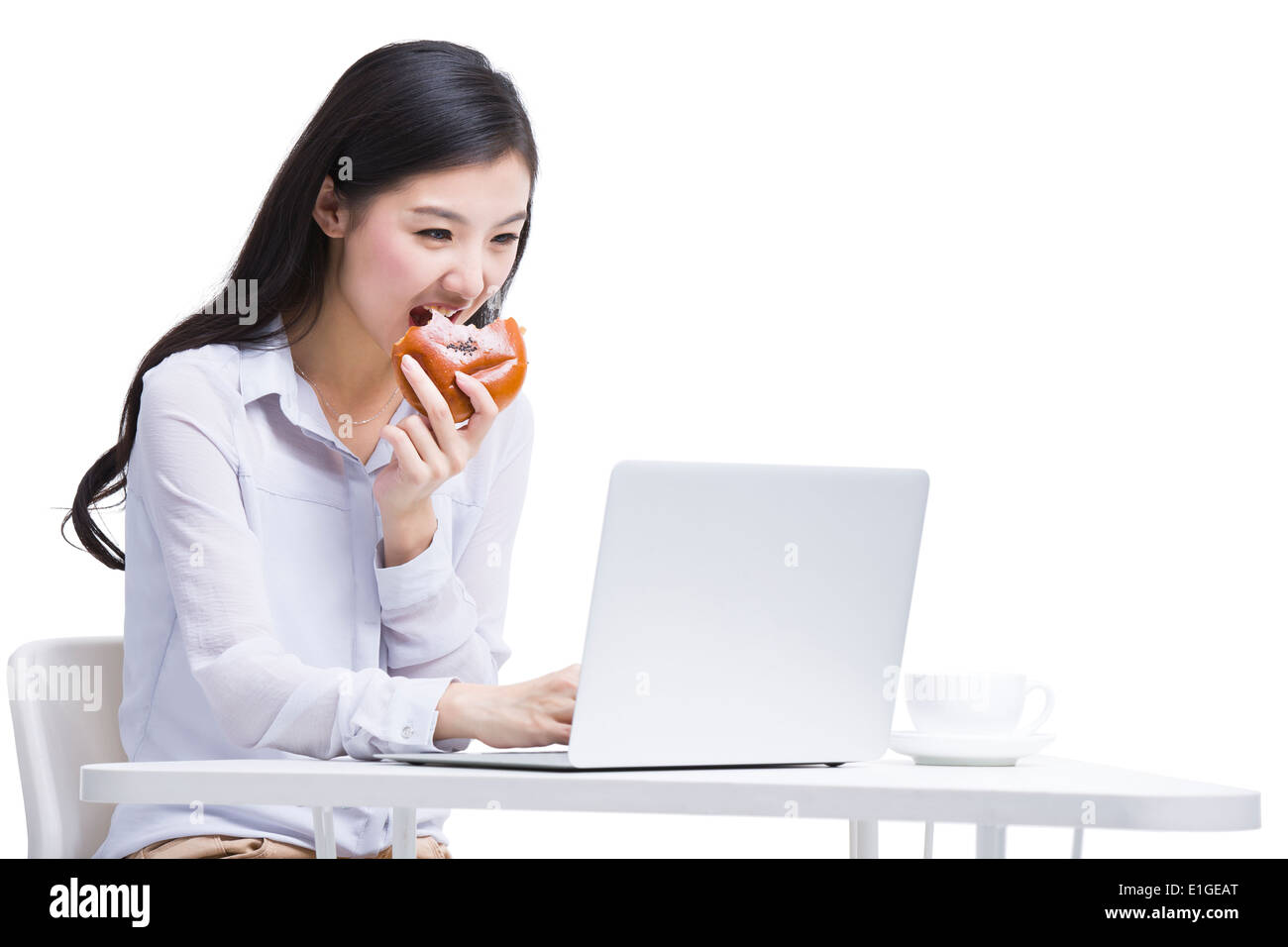 Woman eating at office desk Cut Out Stock Images & Pictures - Alamy