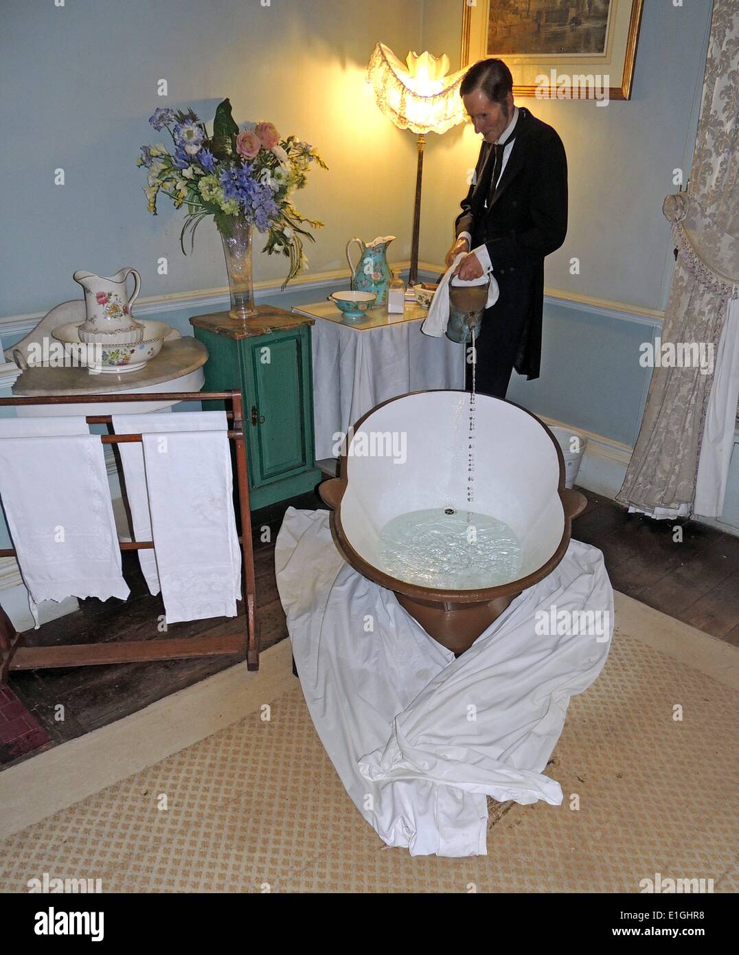 Victorian bath with butler pouring hot water in a tiled en-suite ...