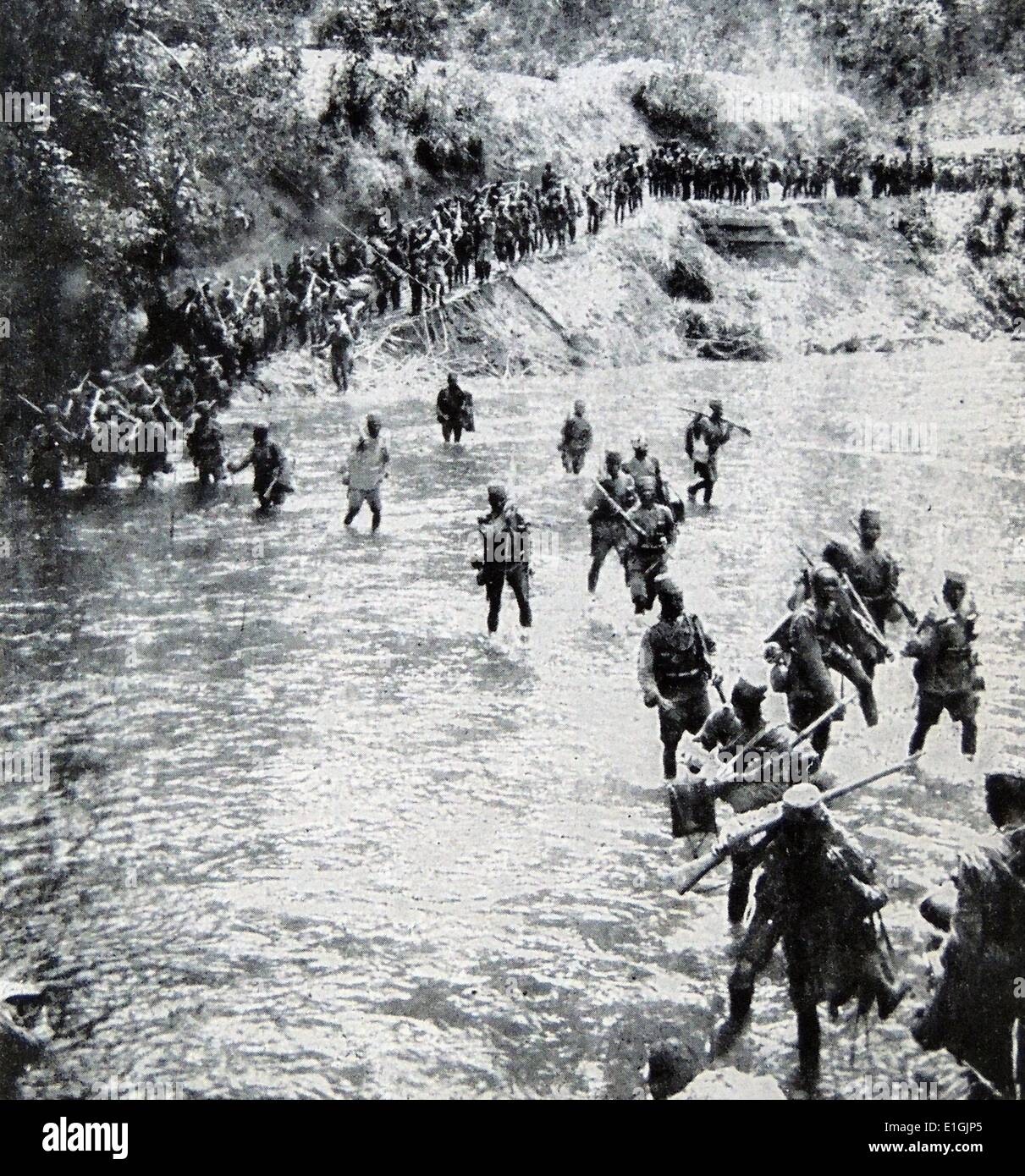 British colonial African soldiers cross a river in East Africa during ...