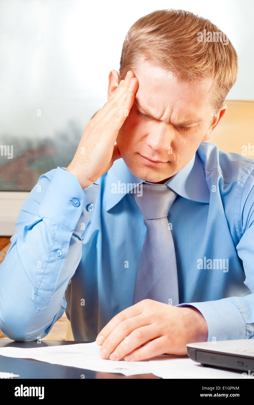 Portrait of a young businessman with headache Stock Photo - Alamy