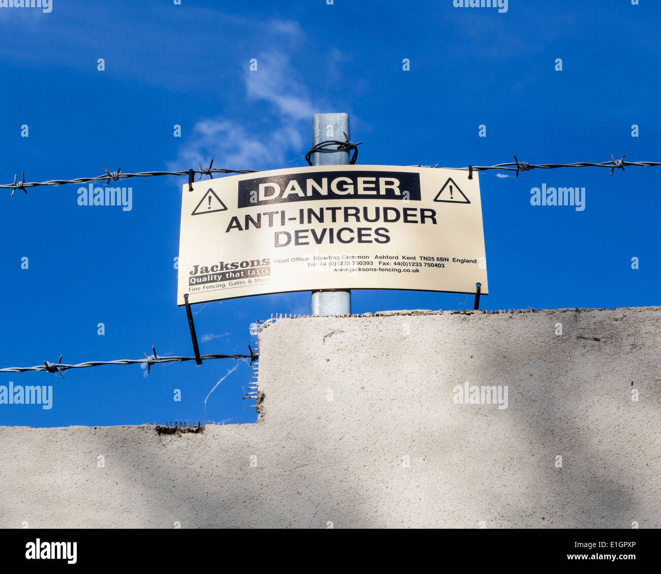 Danger Anti-intruder devices sign and barbed wire on a wall, Thames ...