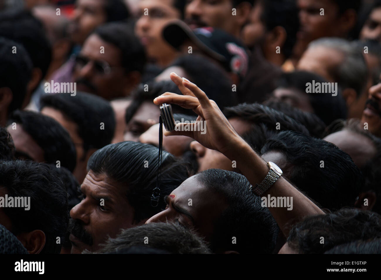 A crowd in India, a hand appears over the crowd holding a camera Stock ...