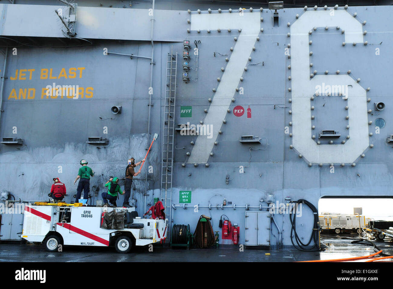 U.S. Sailors scrub down the island superstructure on the flight deck of ...