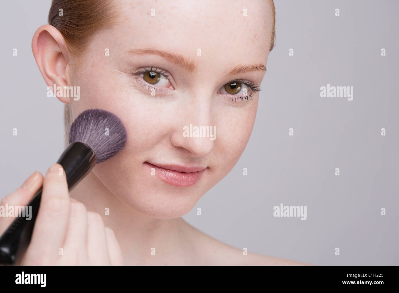 Portrait of young woman, applying make up Stock Photo - Alamy