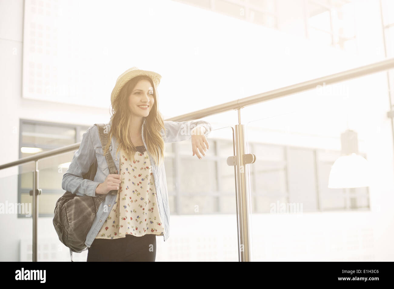 Young woman leaning on railing, portrait Stock Photo - Alamy