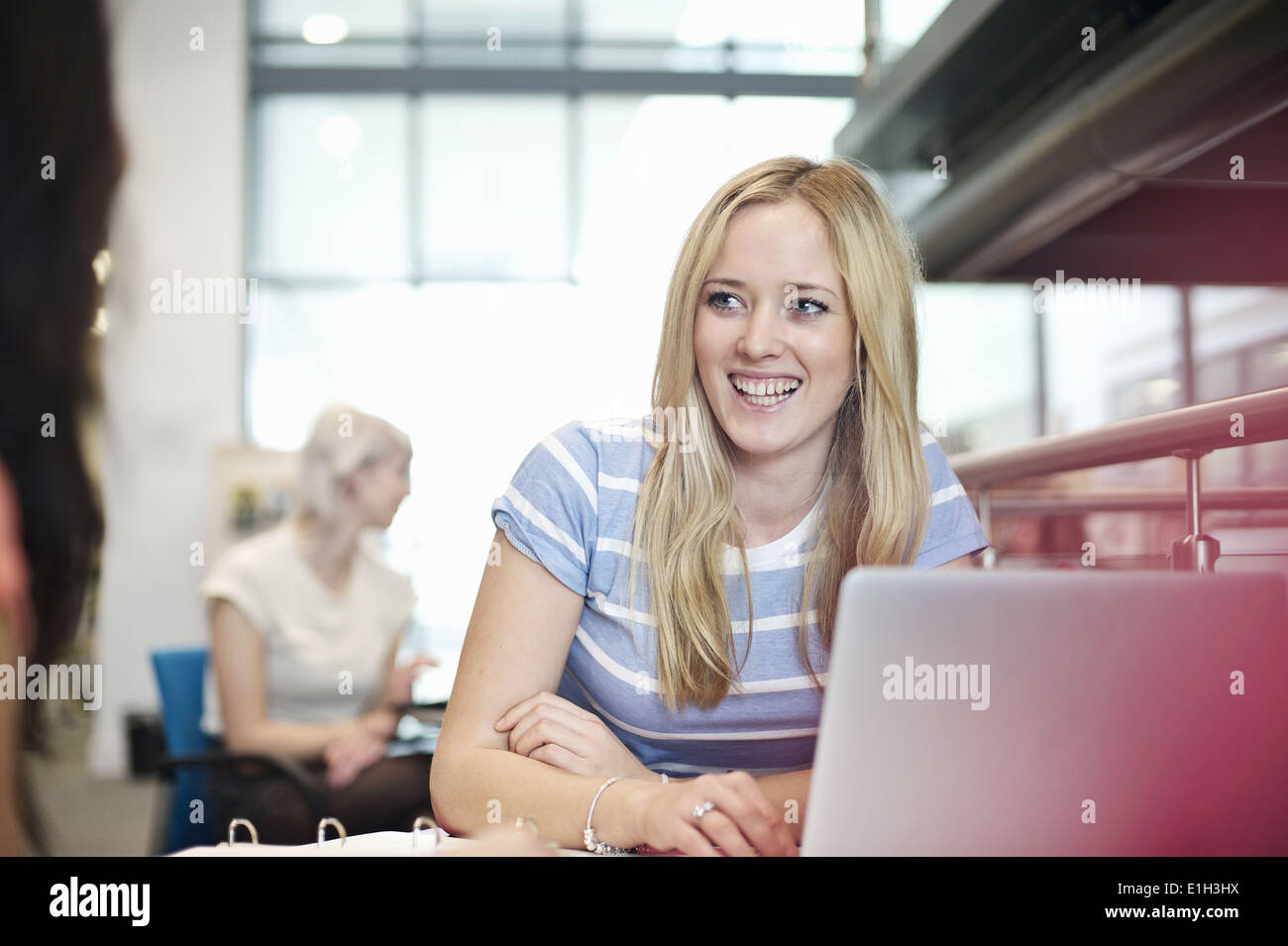Young woman using laptop in library Stock Photo - Alamy