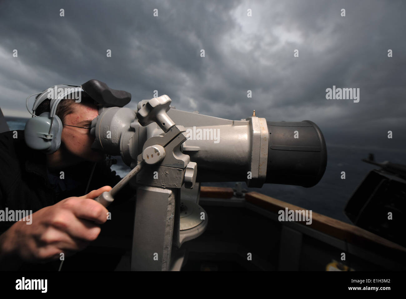 U.S. Navy Operations Specialist Seaman Anthony C. Tyrrell looks through ...