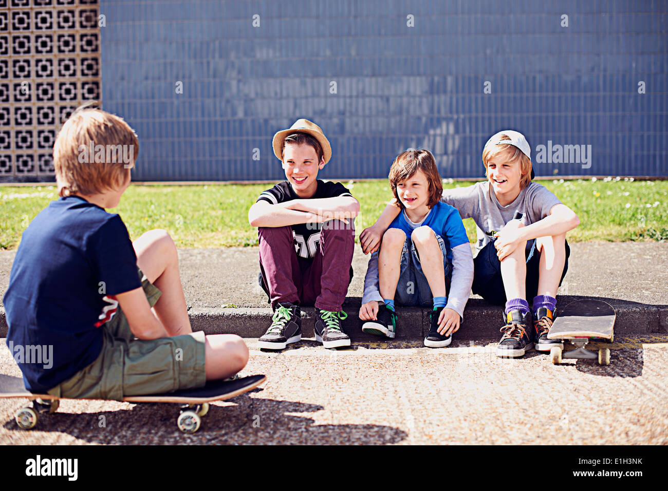 Boys sitting on pavement with skateboards Stock Photo - Alamy
