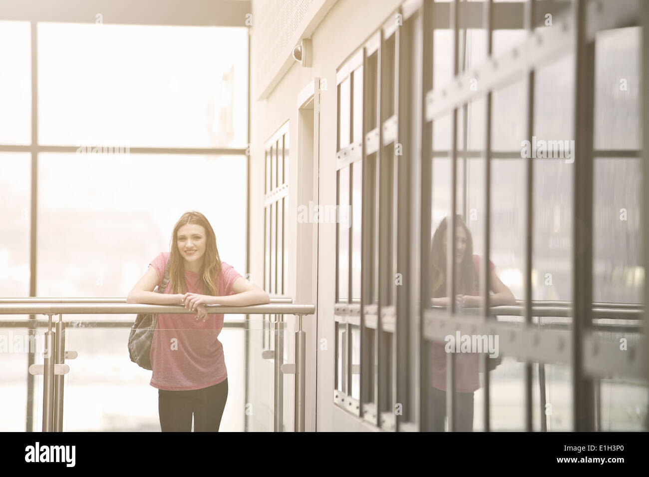 Young woman leaning on railing Stock Photo - Alamy