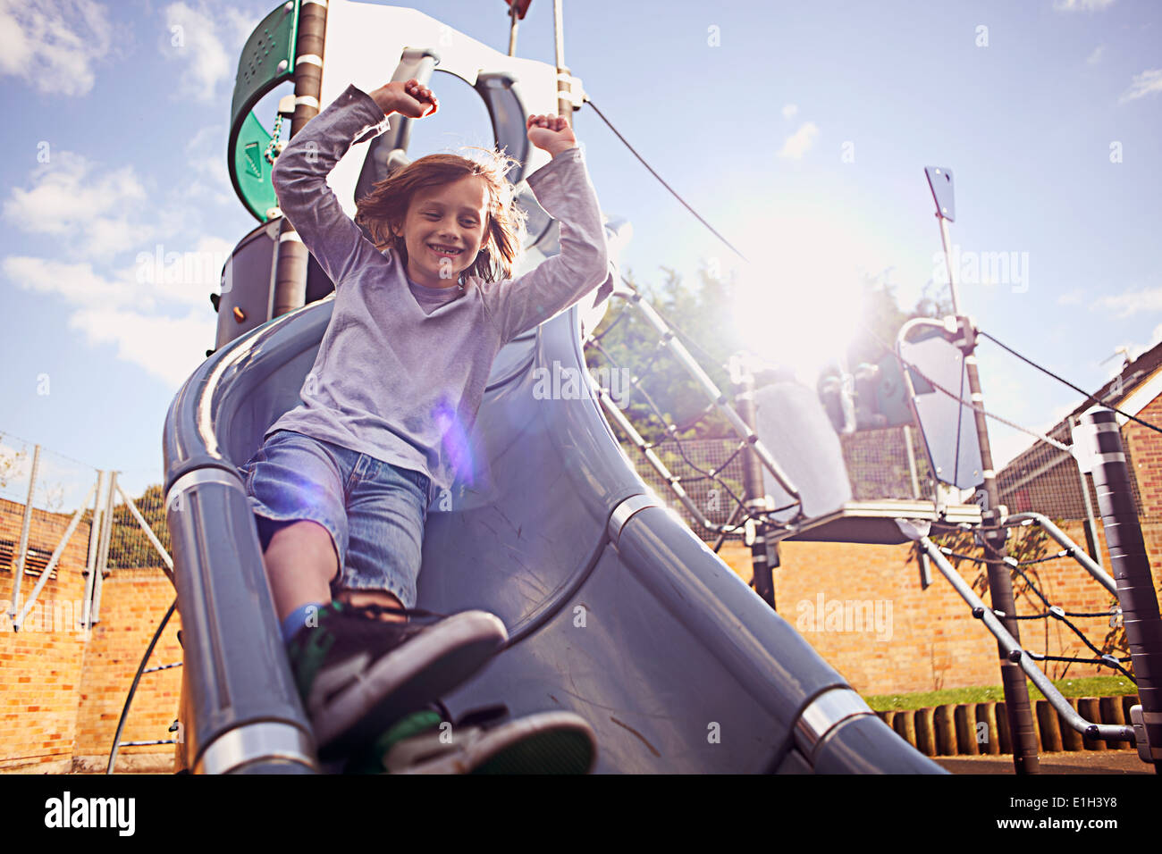 Boy coming down slide Stock Photo - Alamy