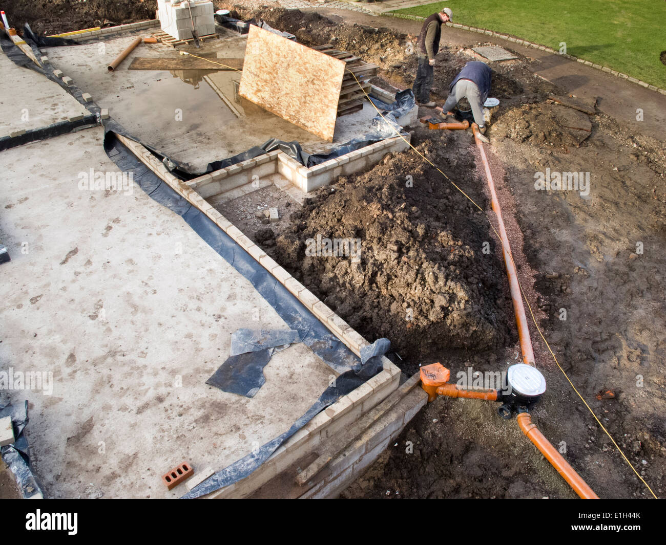 self building house, men setting out drains around house Stock Photo ...