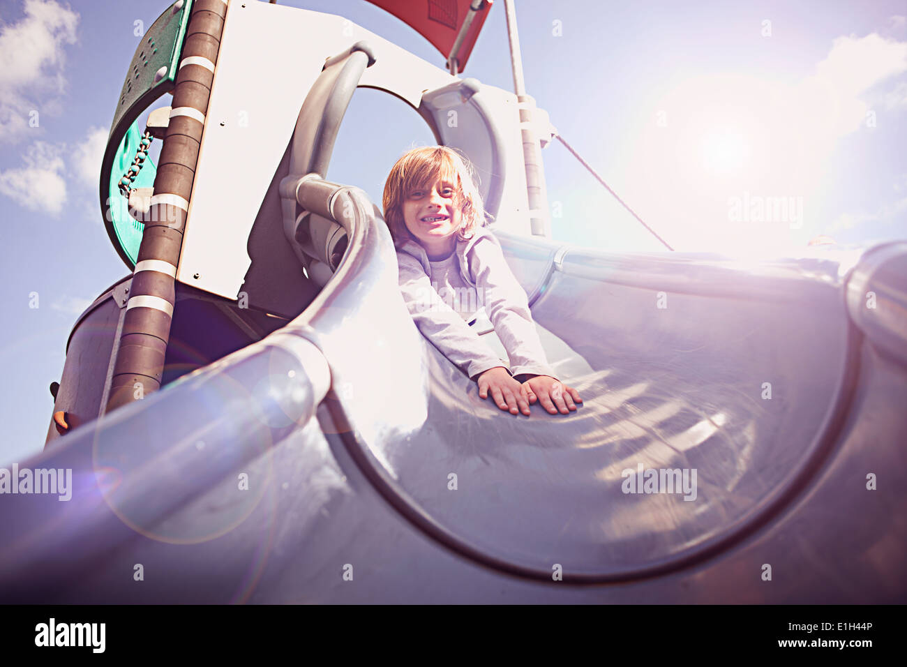 Boy coming down slide on front Stock Photo - Alamy