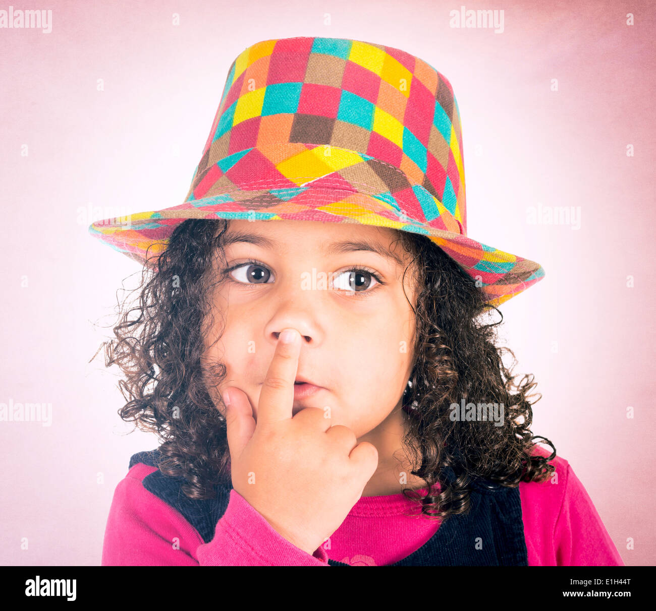 Cute little girl holding her finger on lips Stock Photo - Alamy