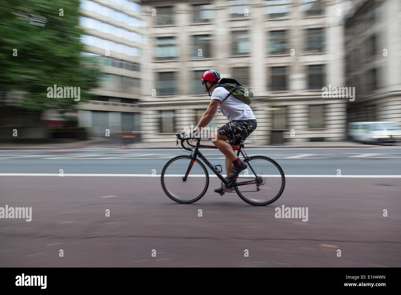 Man wearing a red helmet, camouflage shorts and carrying a backpack ...