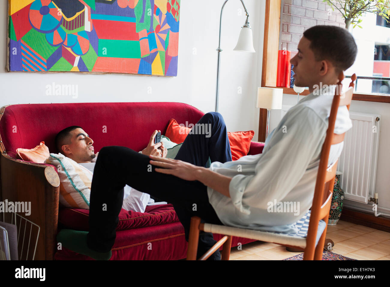 Young men relaxing in living room Stock Photo - Alamy