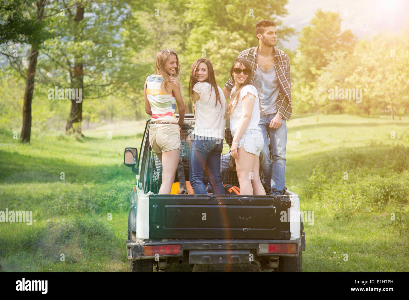 Friends standing on back of off road vehicle Stock Photo - Alamy