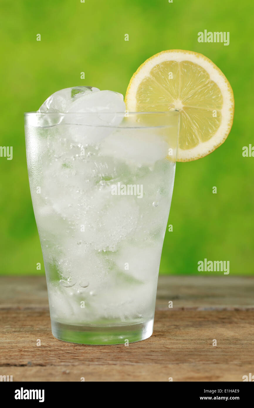 Cold water in a glass with ice cubes, served with a lemon Stock Photo ...