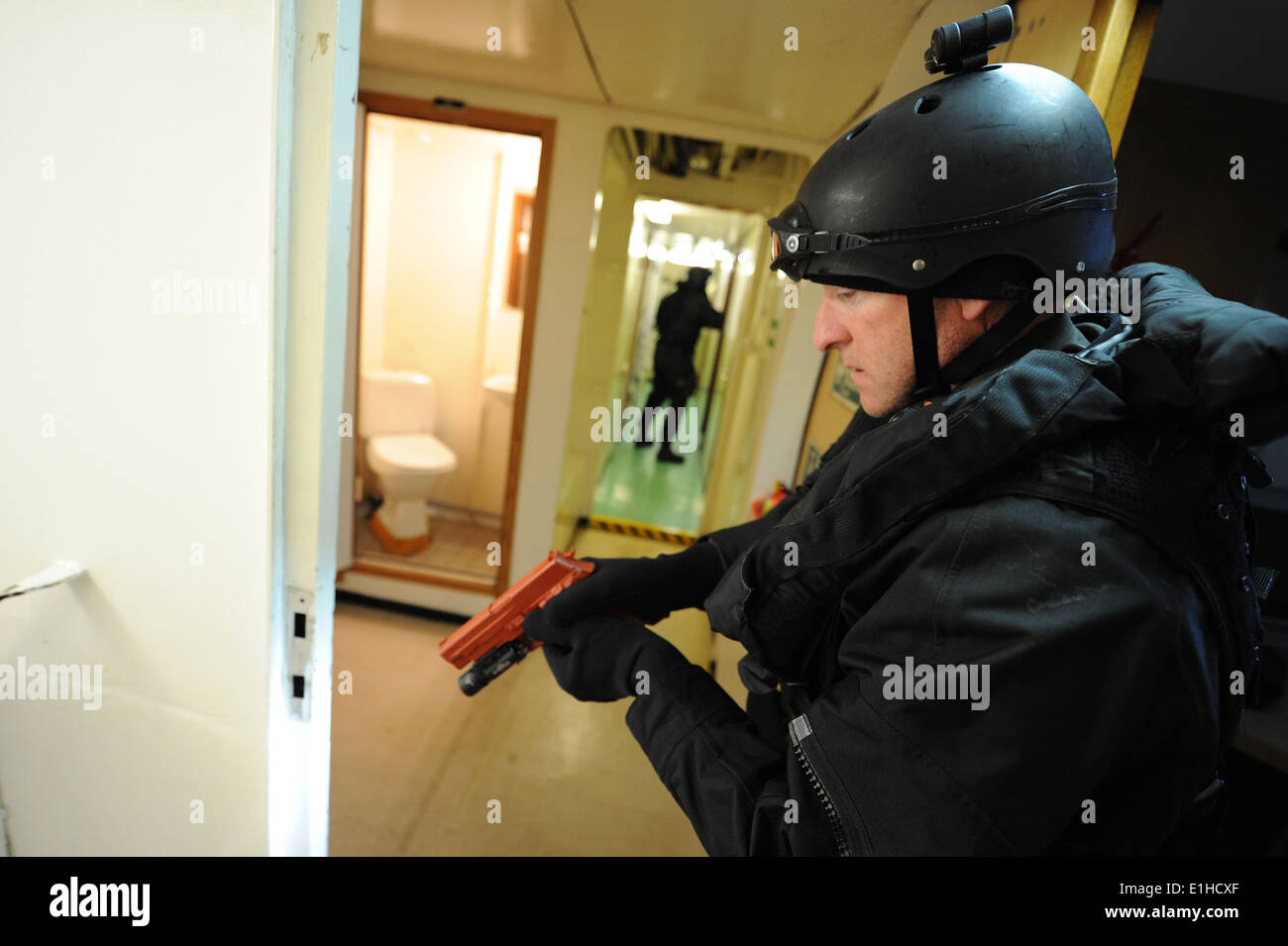 A Royal Canadian Mounted Police officer stands watch as his colleagues ...