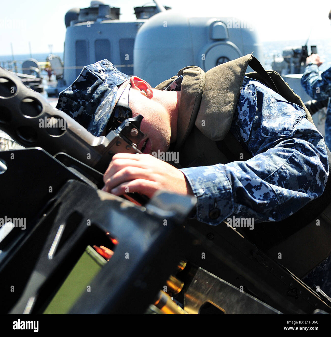 U.S. Navy Fire Controlman Seaman Chase Updike checks the sight of a .50 ...