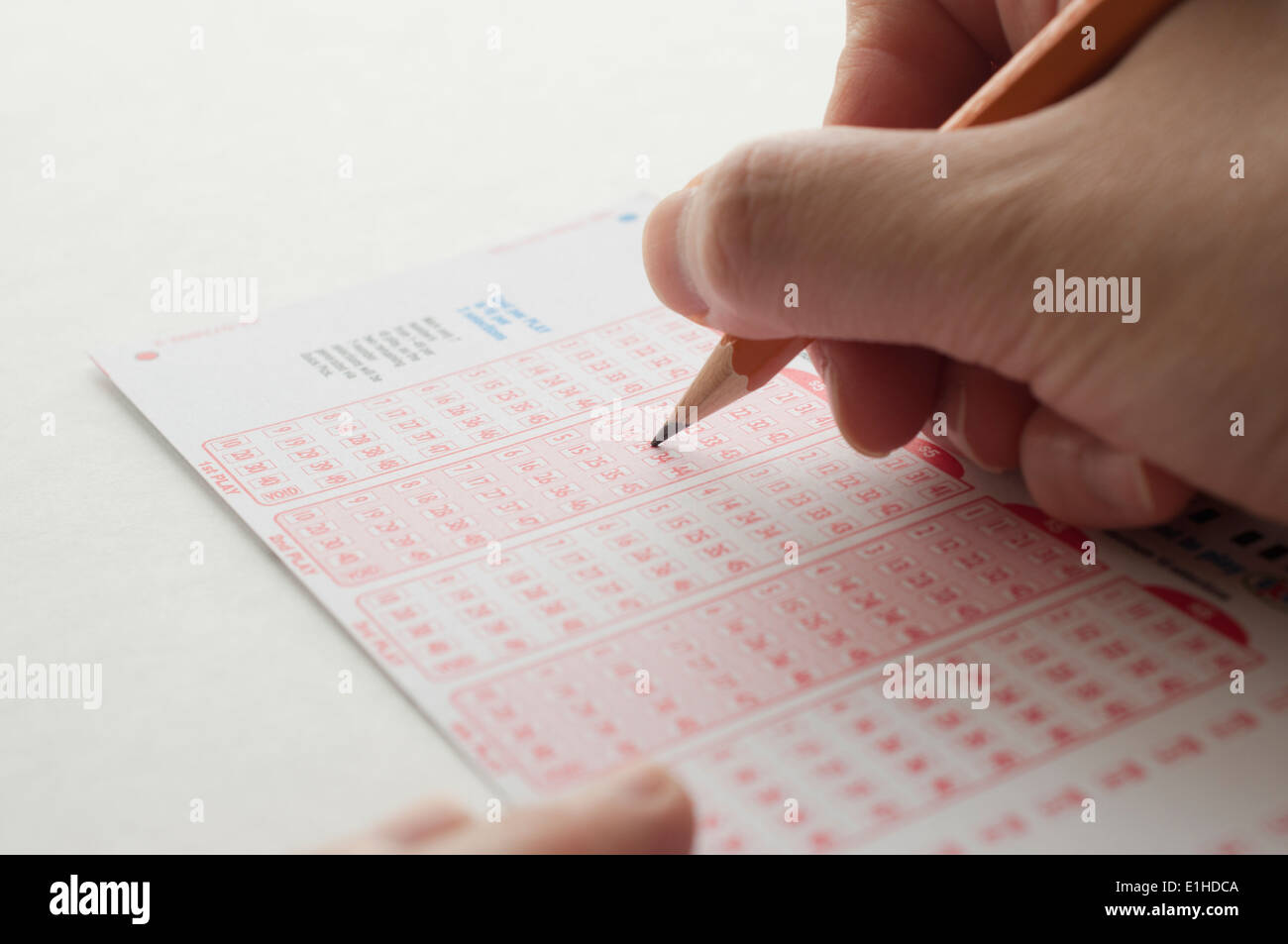 Person marking number on lottery ticket with pen Stock Photo - Alamy